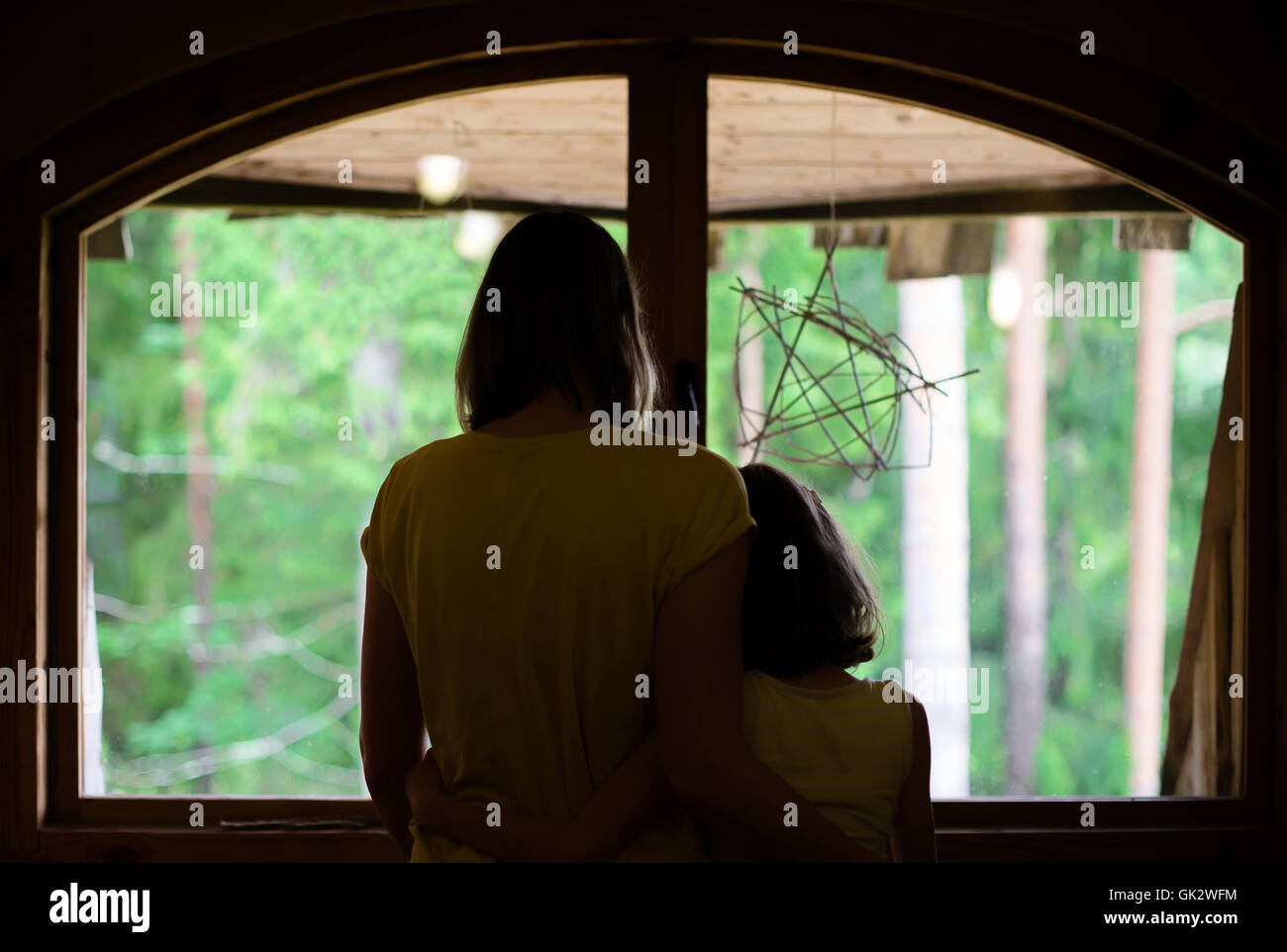 Mother and daughter looking out the window Stock Photo - Alamy