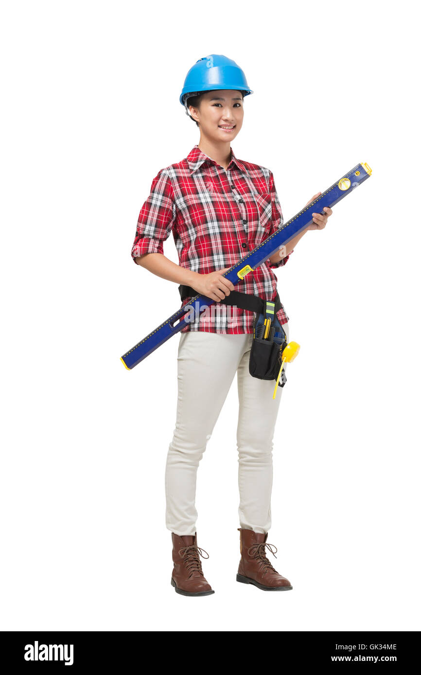 Young female construction worker holding level instrument Stock Photo ...