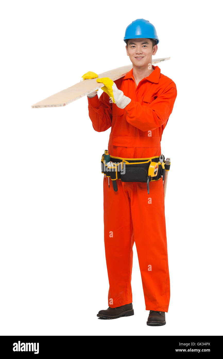 Young construction worker carrying building materials Stock Photo - Alamy