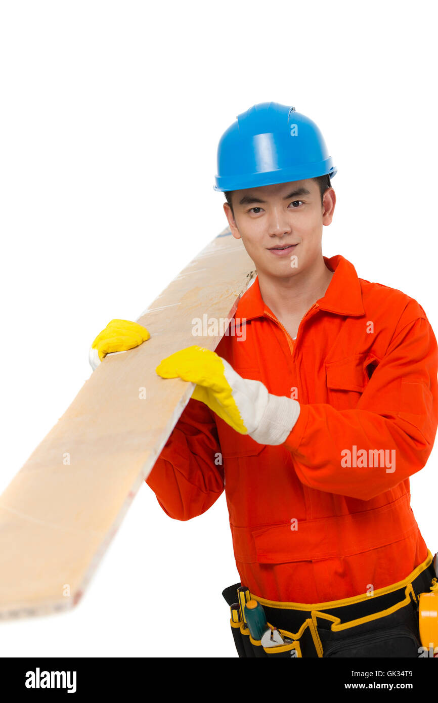 Young construction worker carrying building materials Stock Photo - Alamy