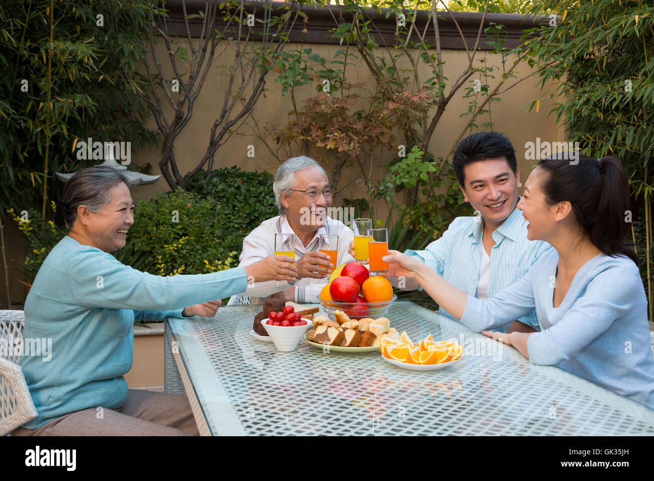 Family eating breakfast in the courtyard Stock Photo - Alamy