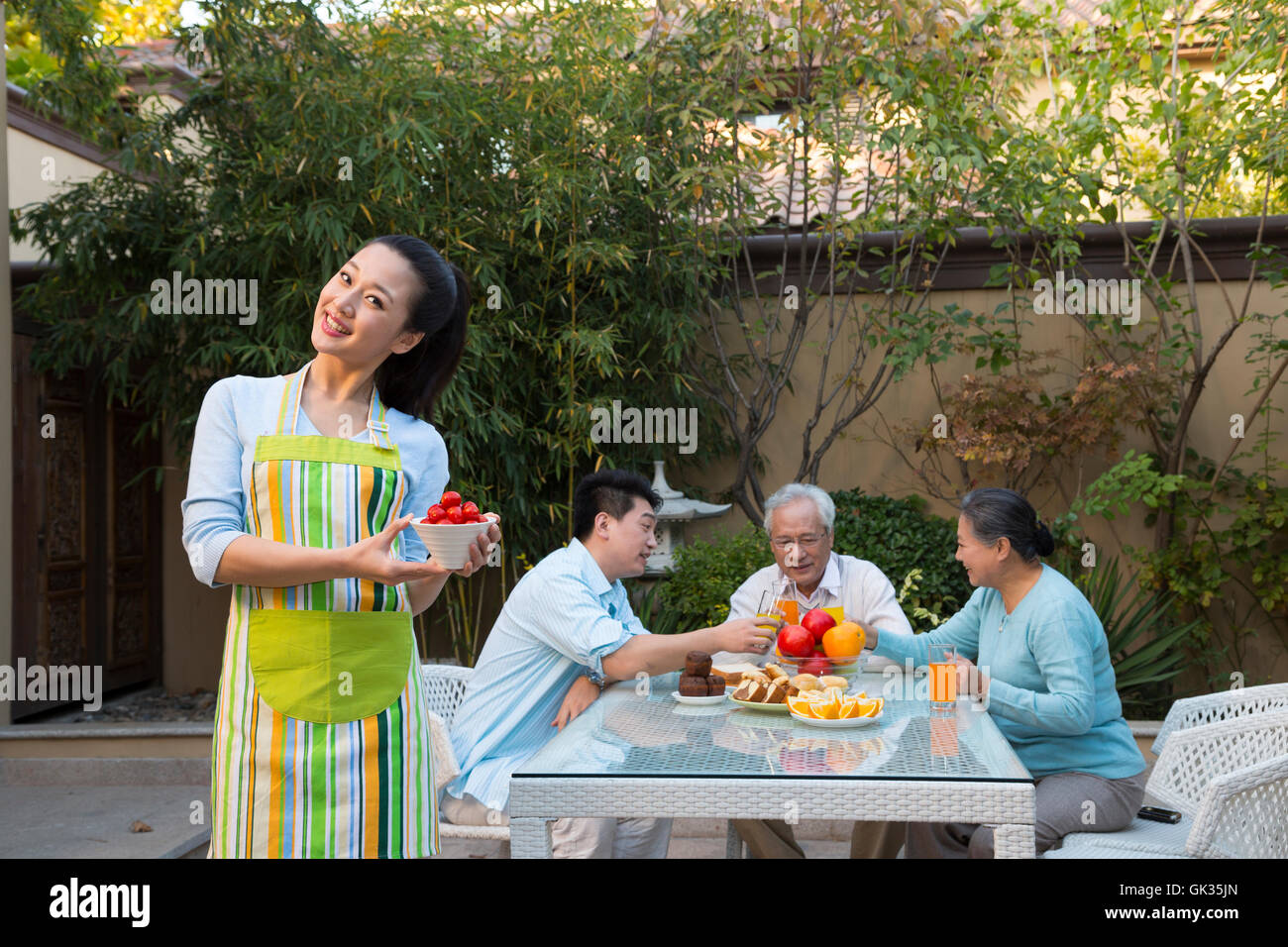 Family eating breakfast in the courtyard Stock Photo - Alamy
