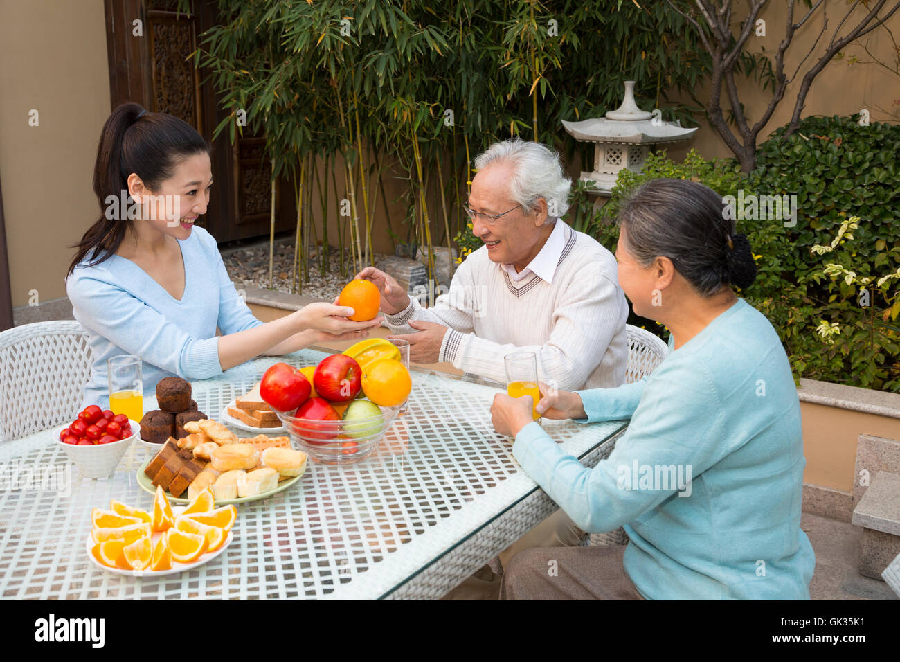 Family eating breakfast in the courtyard Stock Photo - Alamy