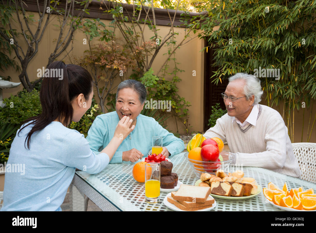 Family eating breakfast in the courtyard Stock Photo - Alamy