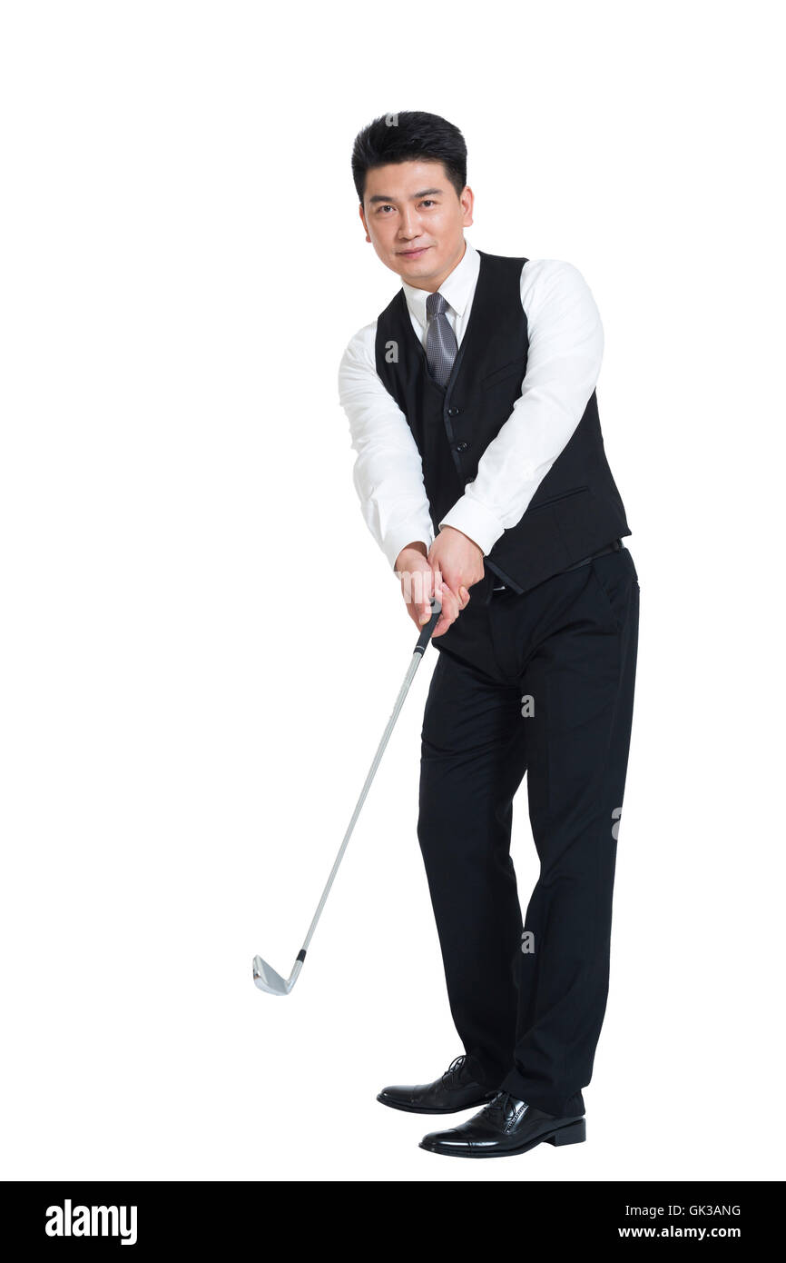 Studio shot business man playing golf Stock Photo - Alamy