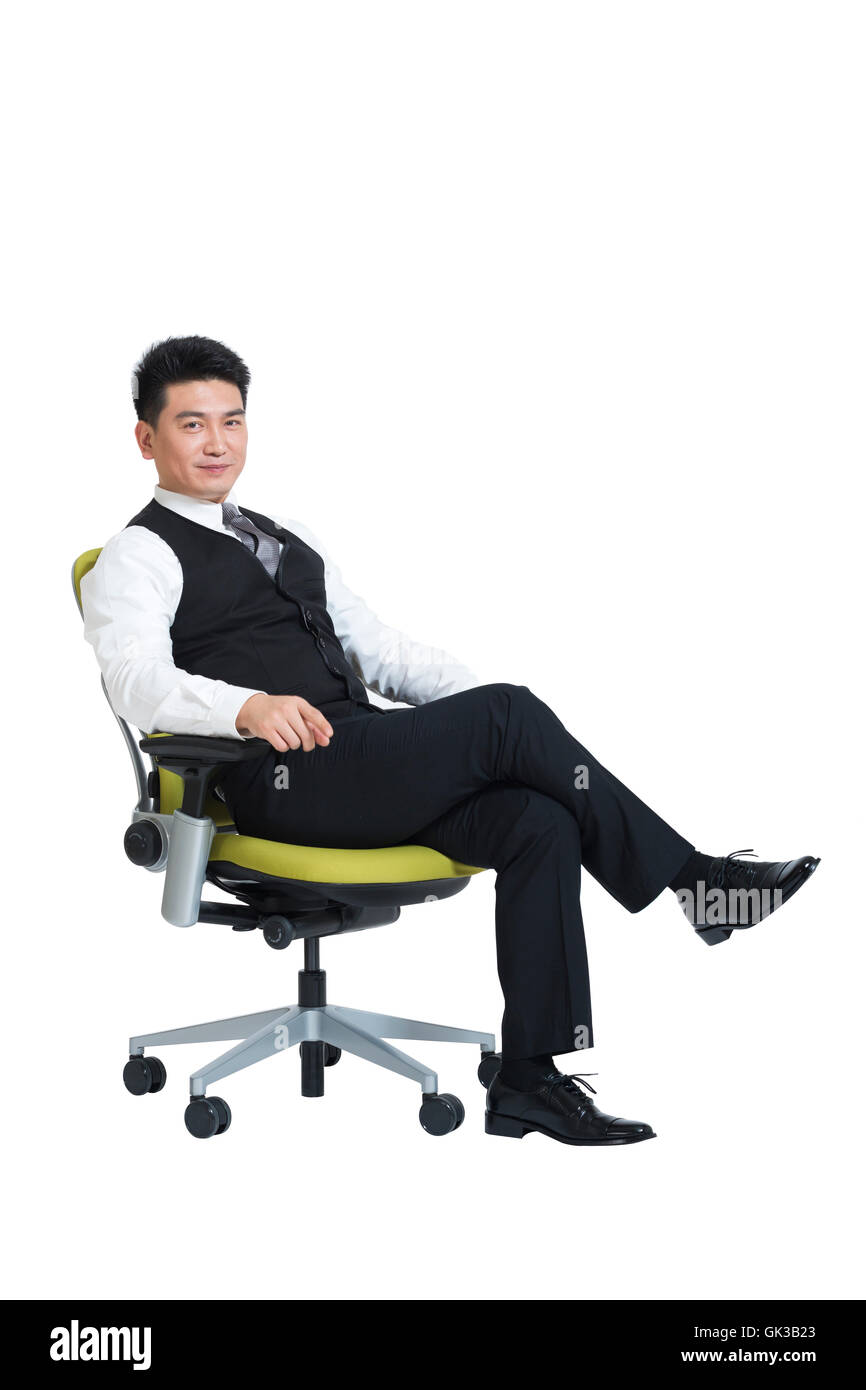 Studio shot business man sitting Stock Photo - Alamy