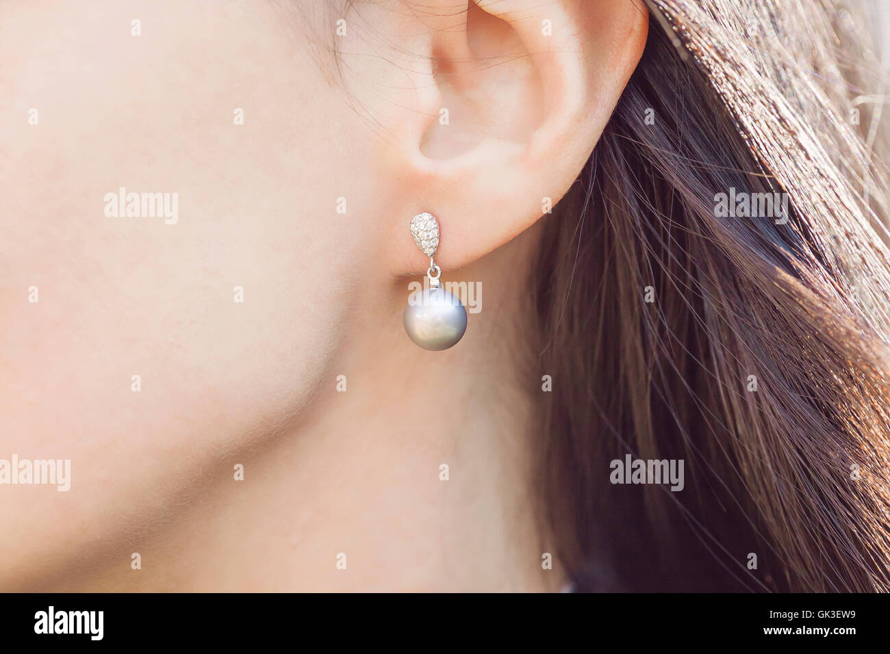 Woman ear wearing beautiful luxury earring Stock Photo - Alamy