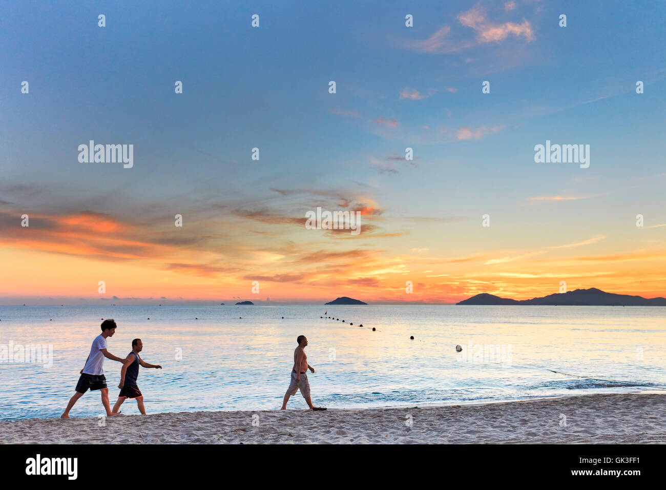 Vietnamese people walking on Cua Dai Beach at sunrise. Hoi An, Quang ...
