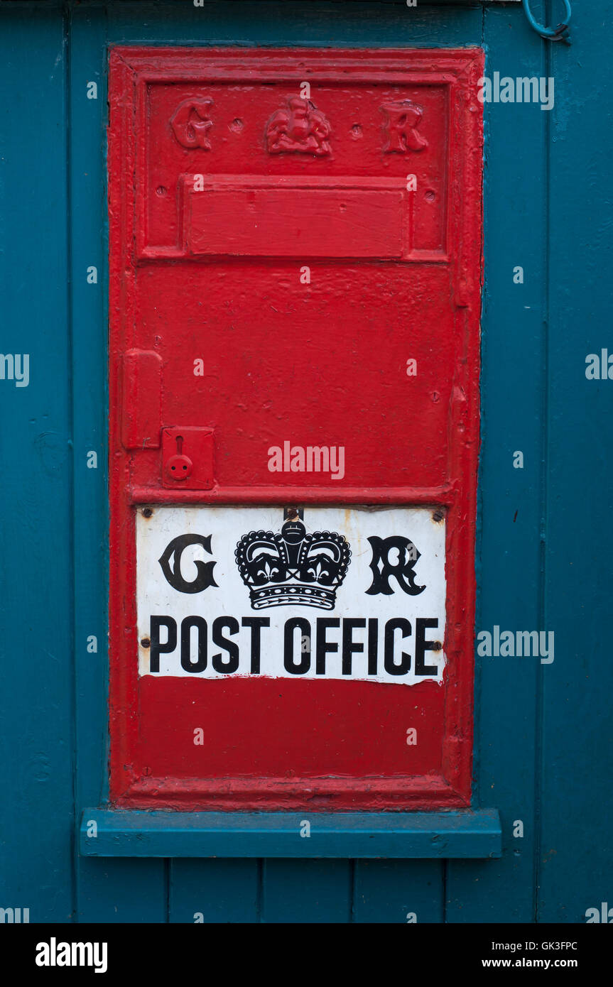 Old red letter box in a blue wall Stock Photo - Alamy