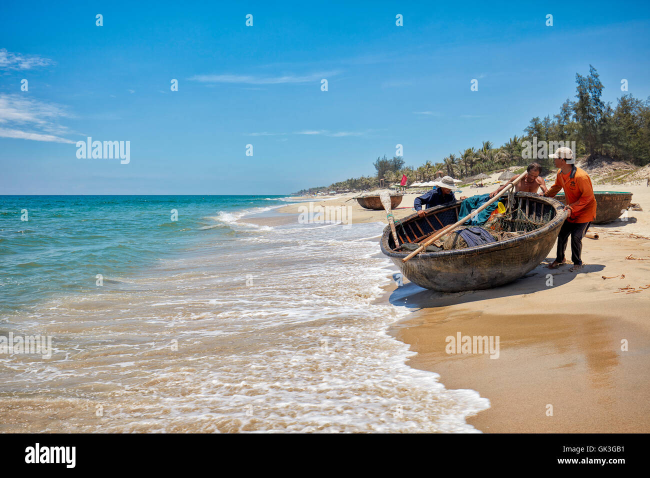 Vietnamese fishermen pull coracle on Cua Dai beach. Hoi An, Quang Nam ...