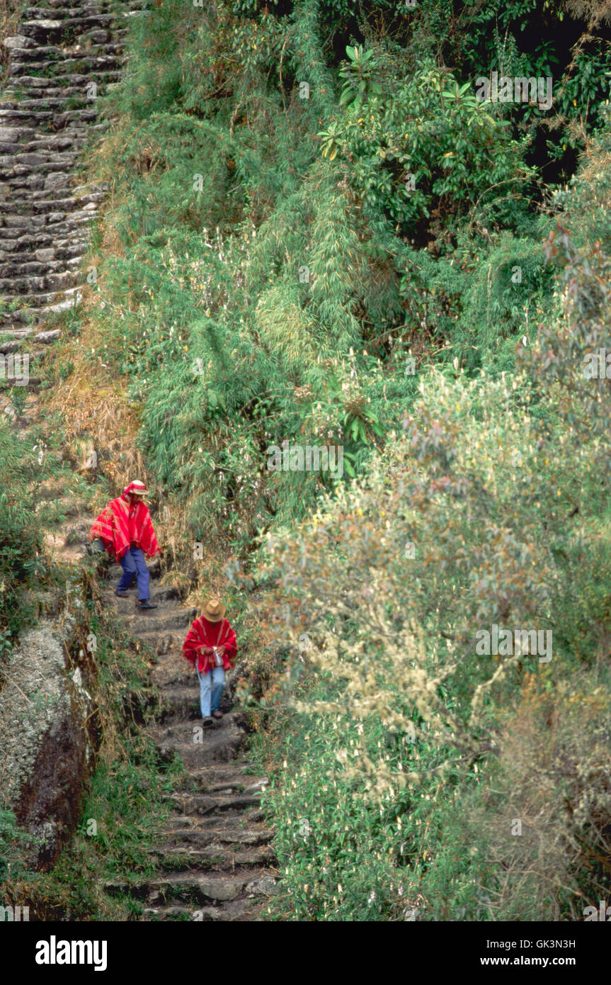 ca. 1980-1995 --- Two men descend the stone steps of an Inca trail ...