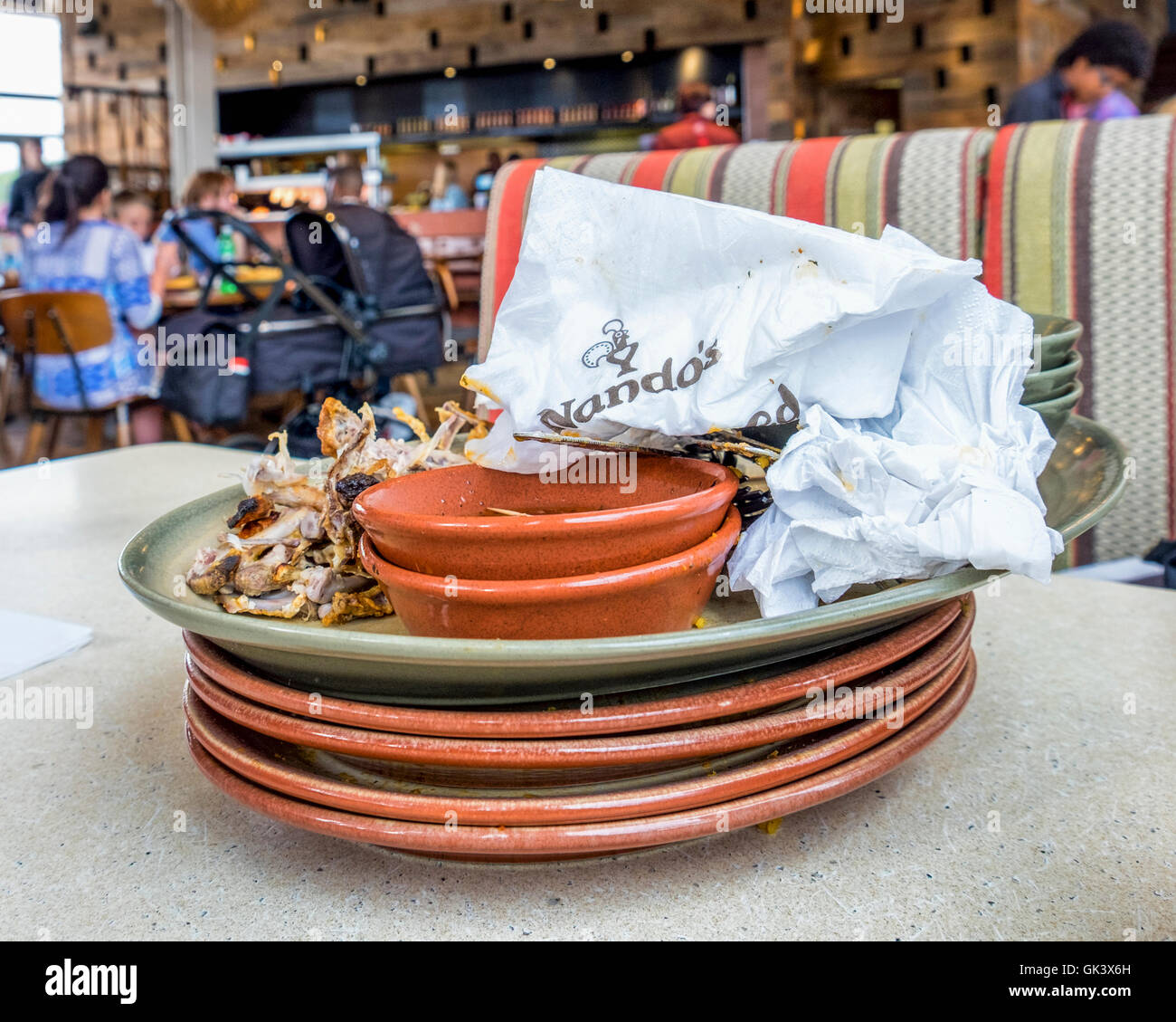 Nando's Restaurant interior after meal with empty stacked plates, bones ...