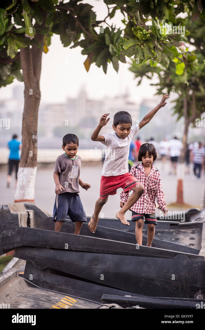 Three young boys play on a rubbish tip in Mumbai, India Credit: Euan ...