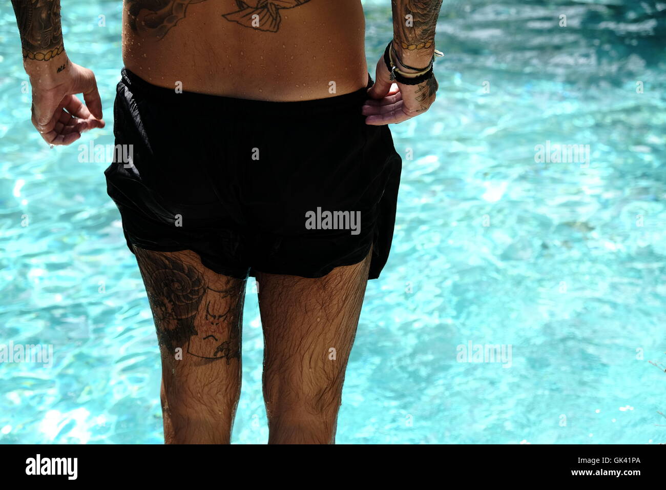 Man in swimming shorts at the side of a swimming pool Stock Photo - Alamy