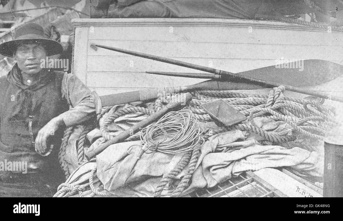 An indigenous hunter aboard a sealing canoe demonstrates traditional ...