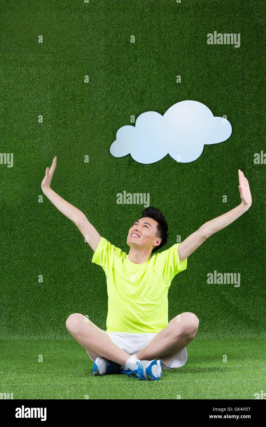 Creative young man sitting on the grass Stock Photo - Alamy