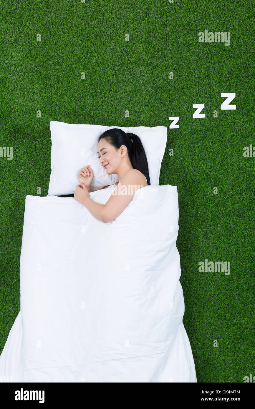 Creative meadow sleeping young woman Stock Photo - Alamy