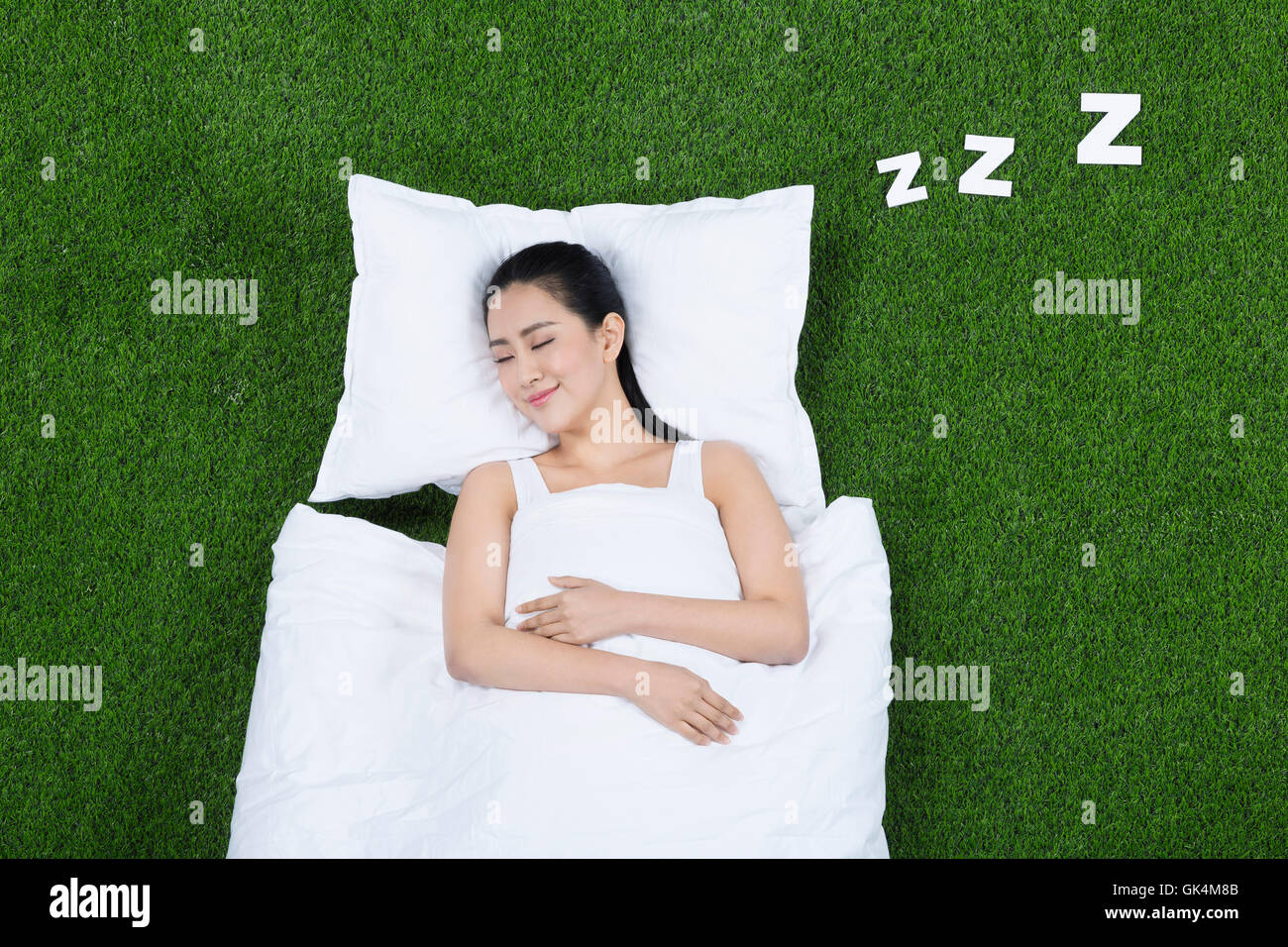Creative meadow sleeping young woman Stock Photo - Alamy