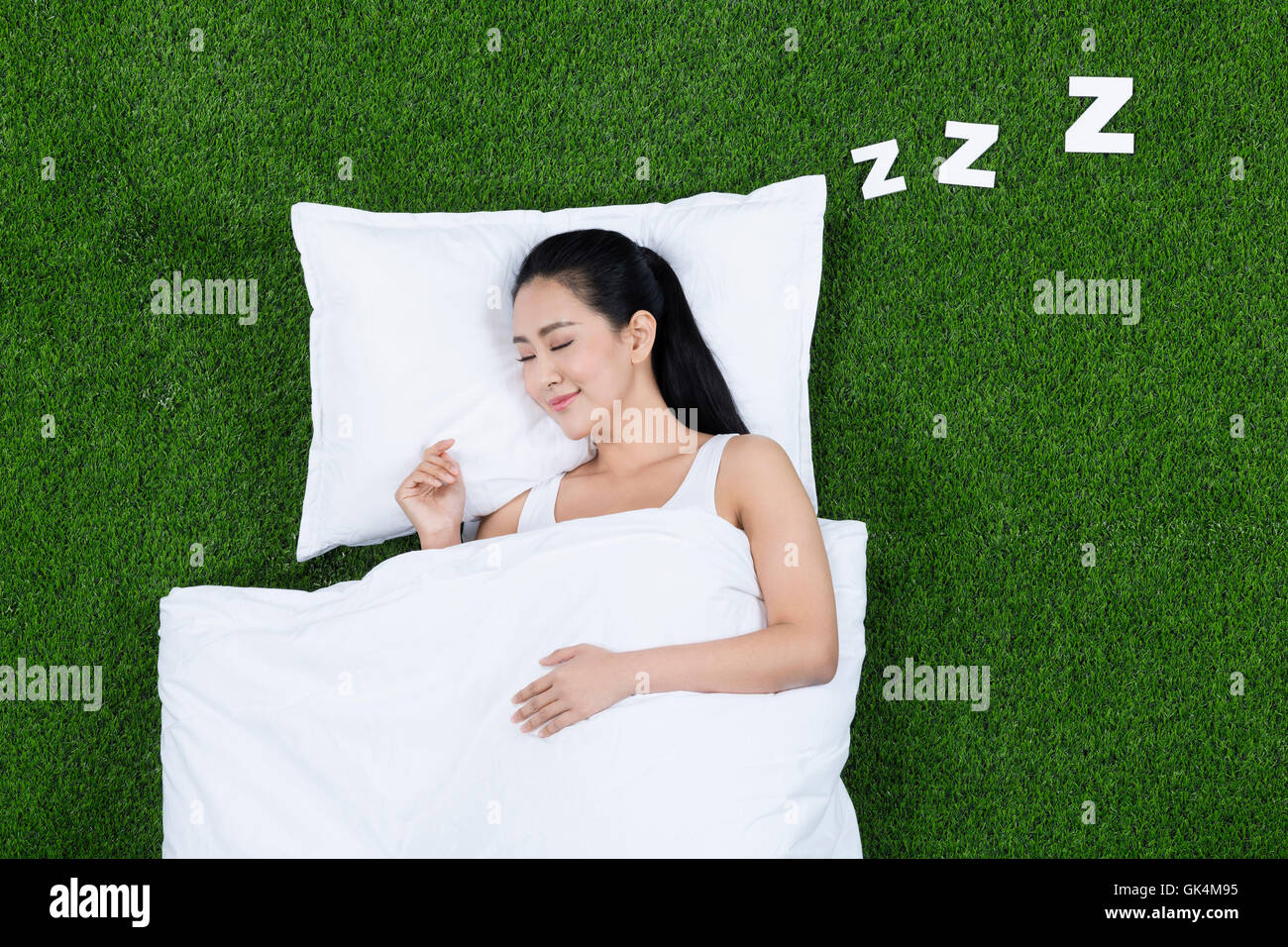 Creative meadow sleeping young woman Stock Photo - Alamy