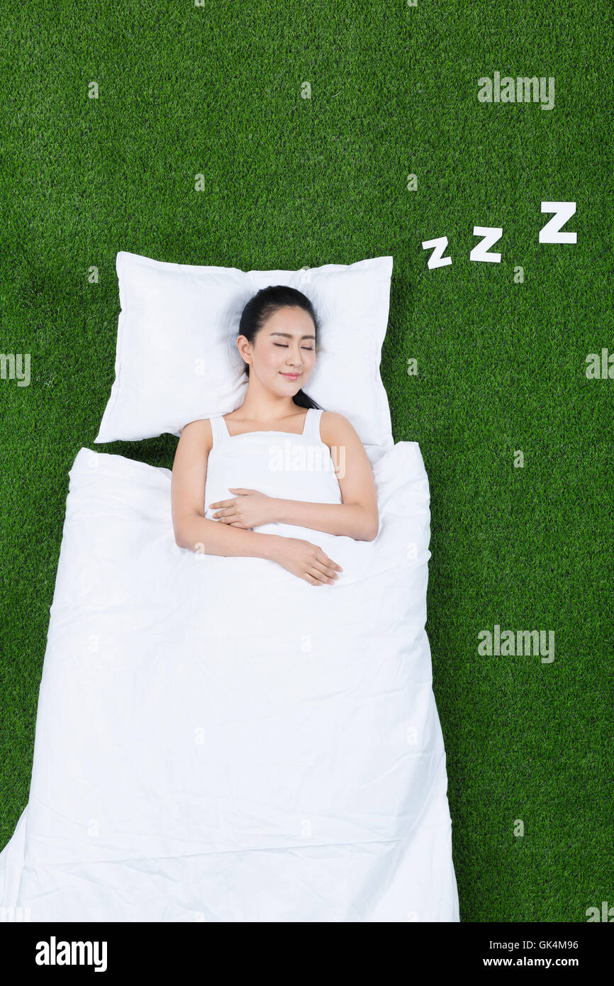 Creative meadow sleeping young woman Stock Photo - Alamy