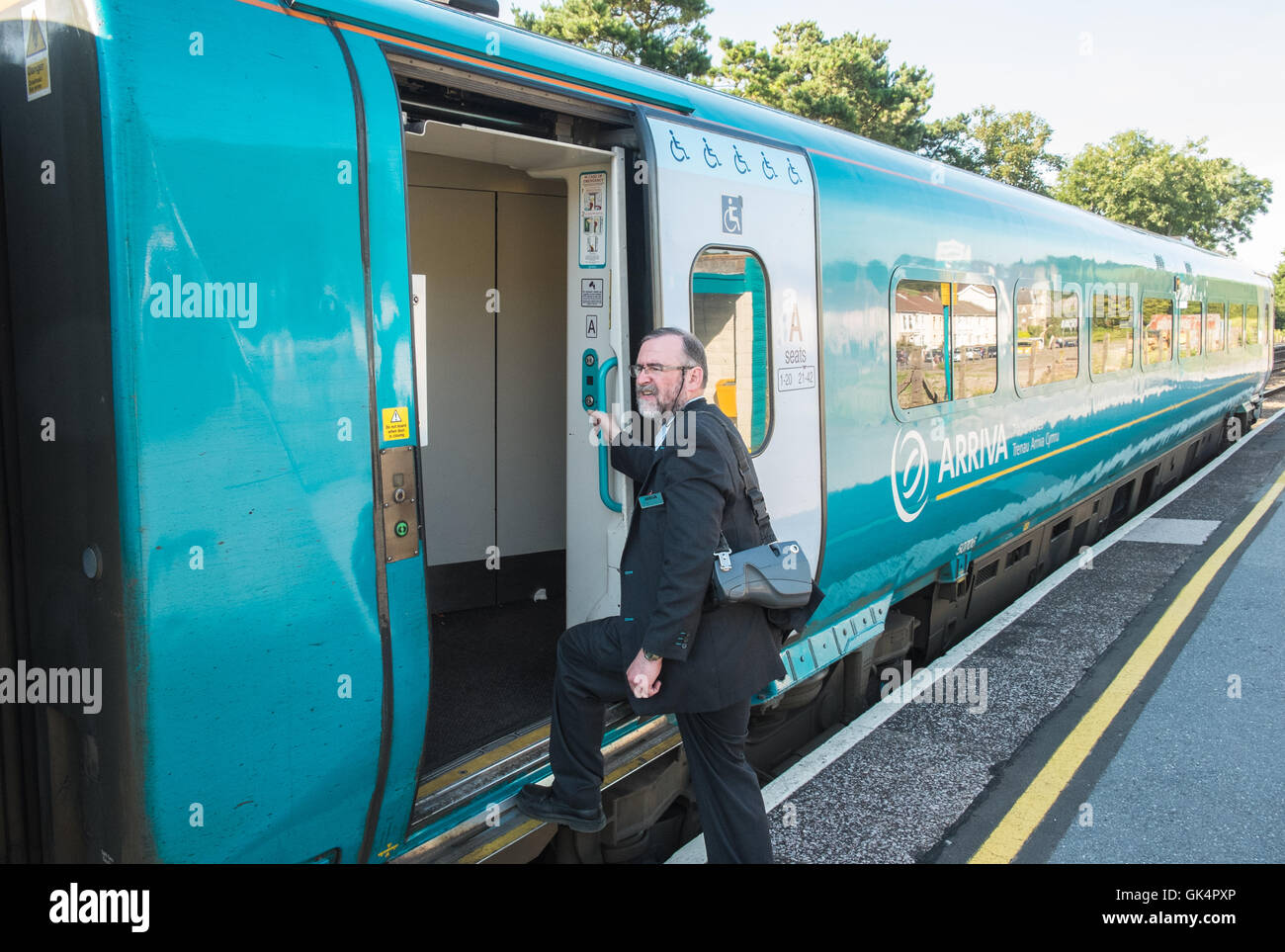Train Guard checking passengers getting on and off two carriage Arriva ...