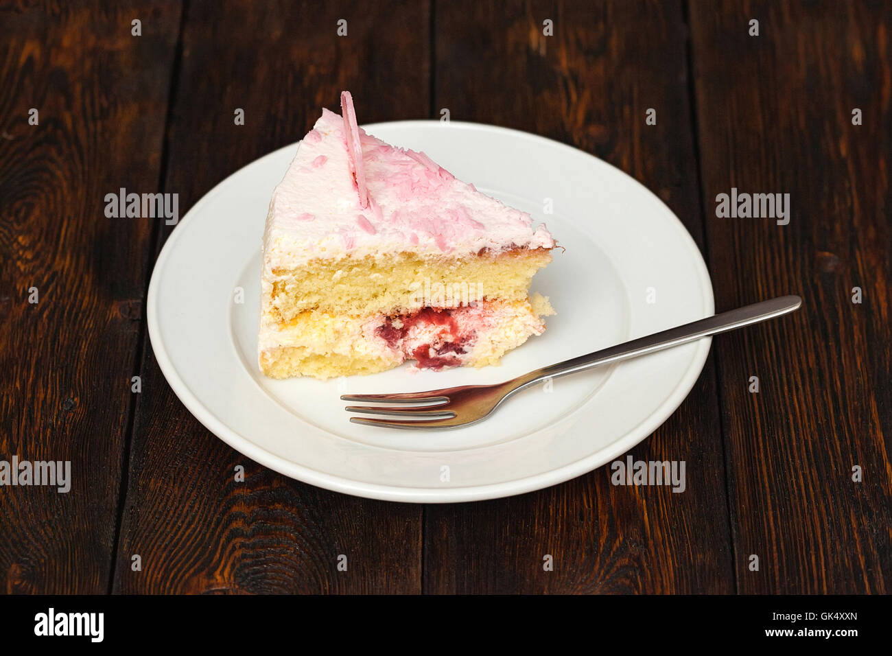 Pink cake slice on dark wooden background Stock Photo - Alamy