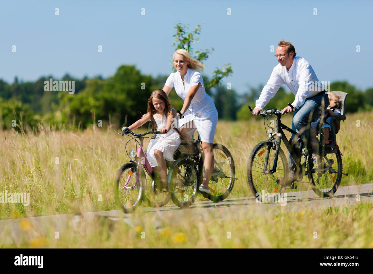 family rides a bike in the summer Stock Photo - Alamy