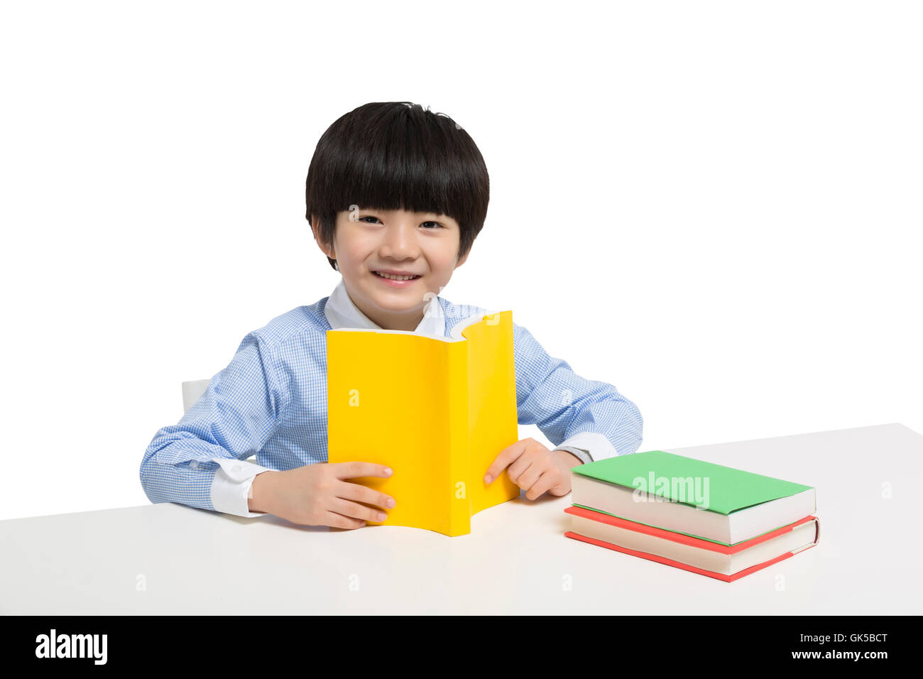The little boy at the desk reading a book Stock Photo - Alamy