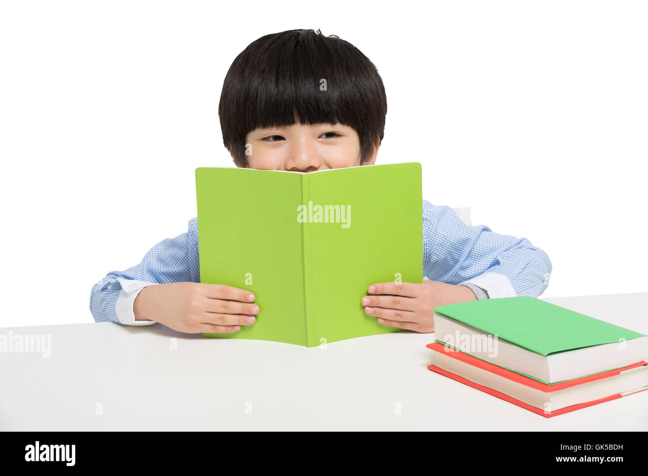 The little boy at the desk reading a book Stock Photo - Alamy