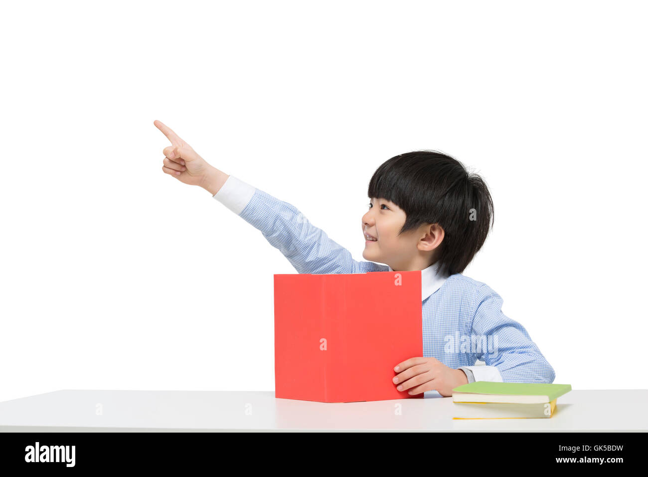 The little boy at the desk reading a book Stock Photo - Alamy
