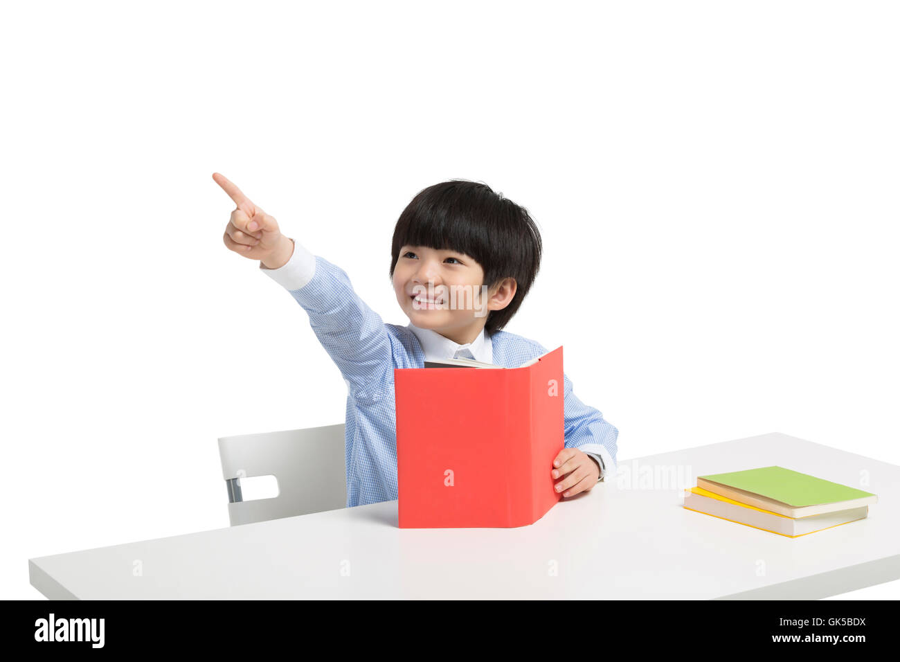 The little boy at the desk reading a book Stock Photo - Alamy