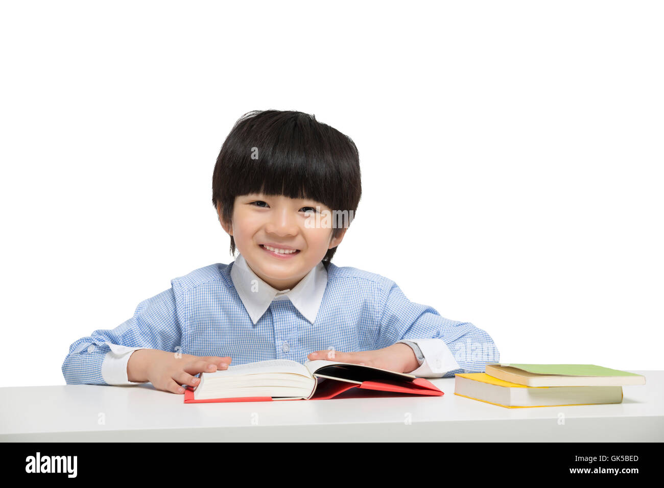 The little boy at the desk reading a book Stock Photo - Alamy