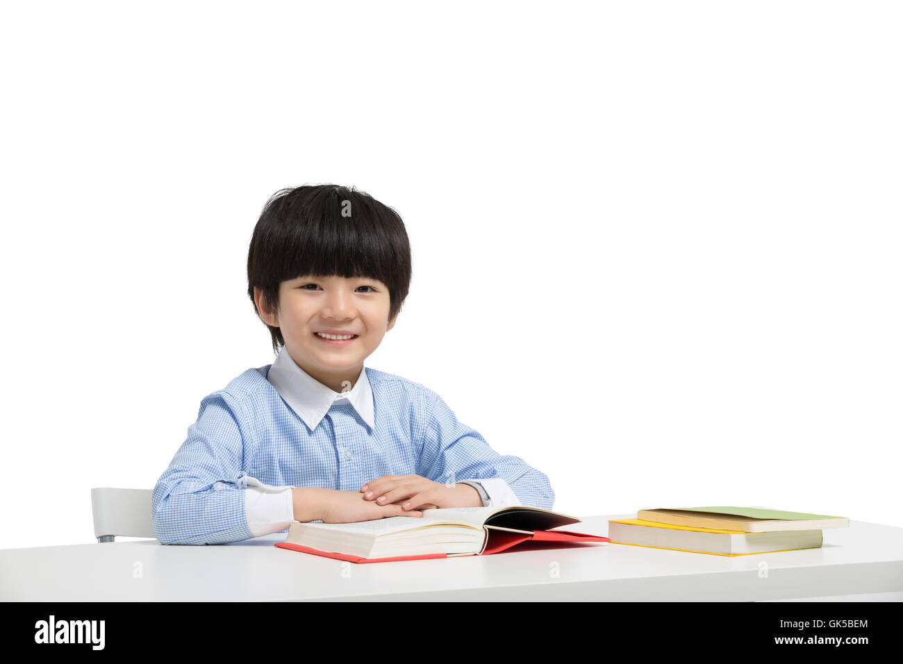 The little boy at the desk reading a book Stock Photo - Alamy