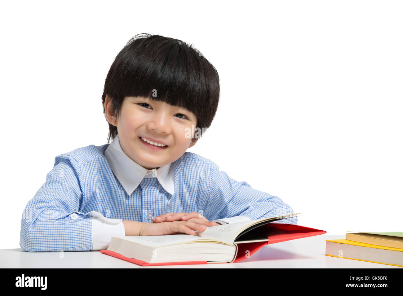 The little boy at the desk reading a book Stock Photo - Alamy