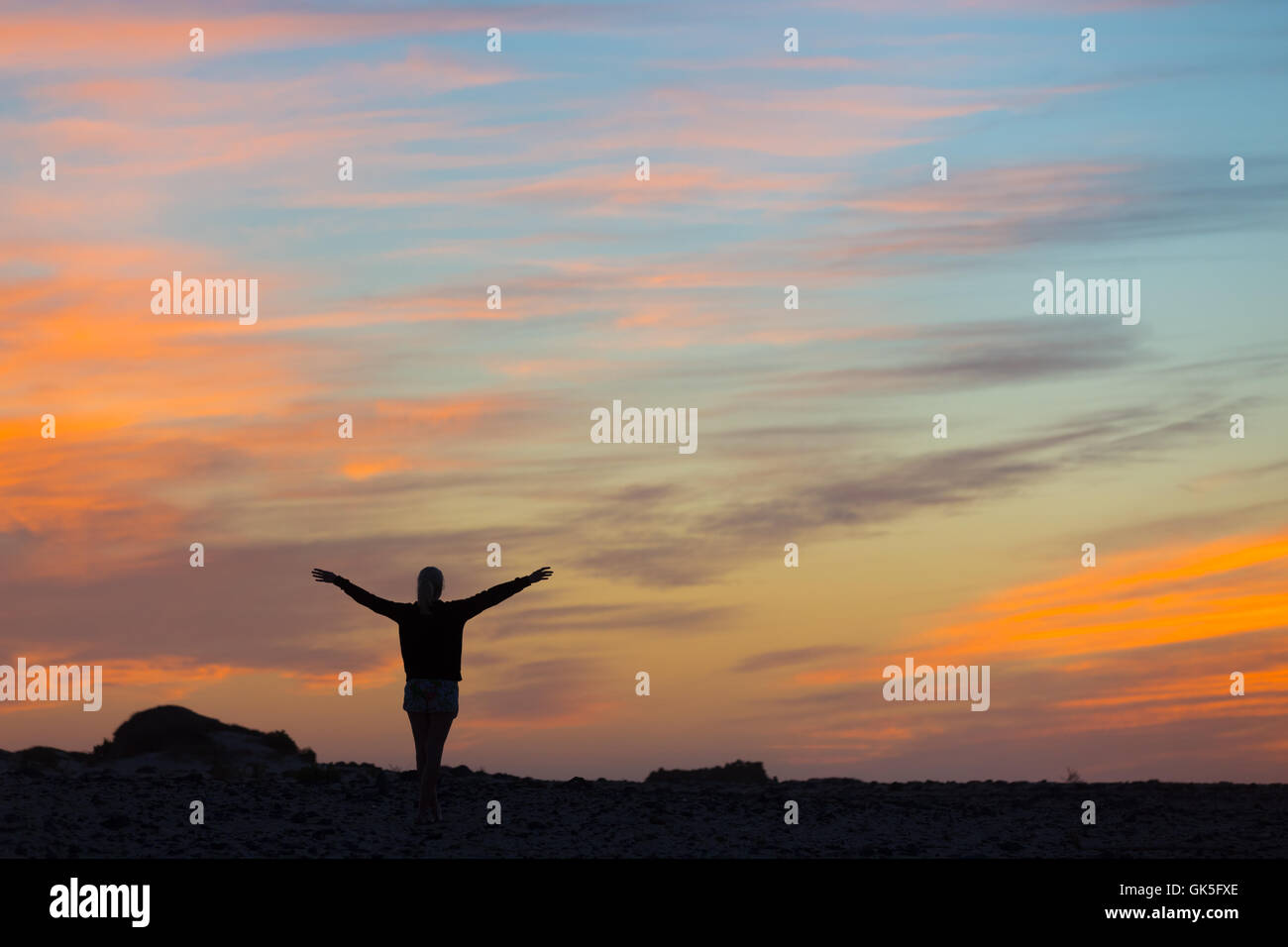 Silhouette of free woman enjoying freedom feeling happy at sunset ...