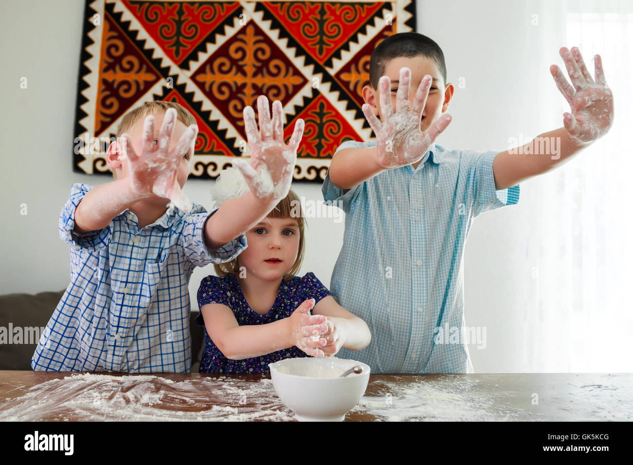 Cooking fun: children preparing dough and playing with flour Stock ...