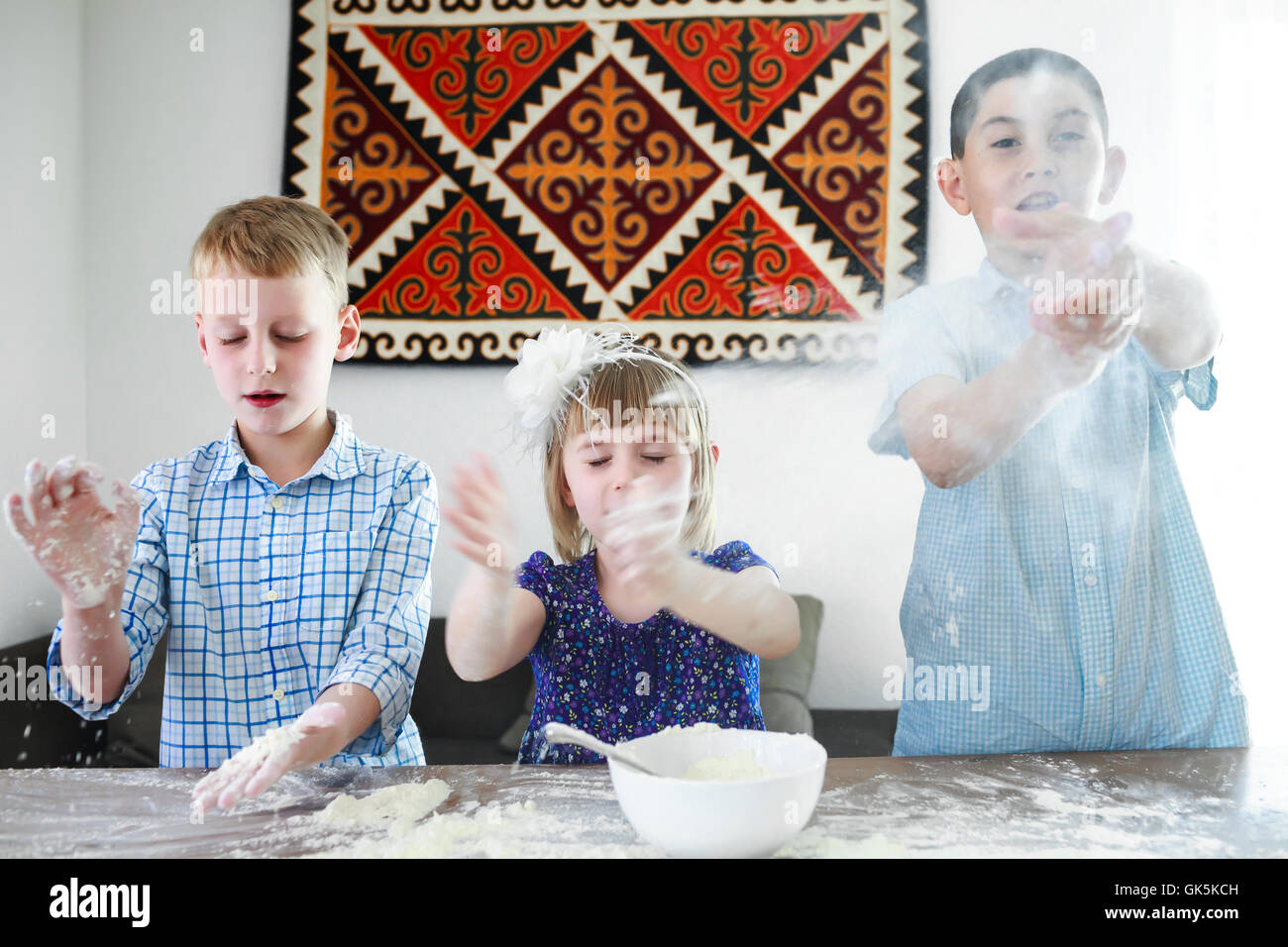Cooking fun: children preparing dough and playing with flour Stock ...