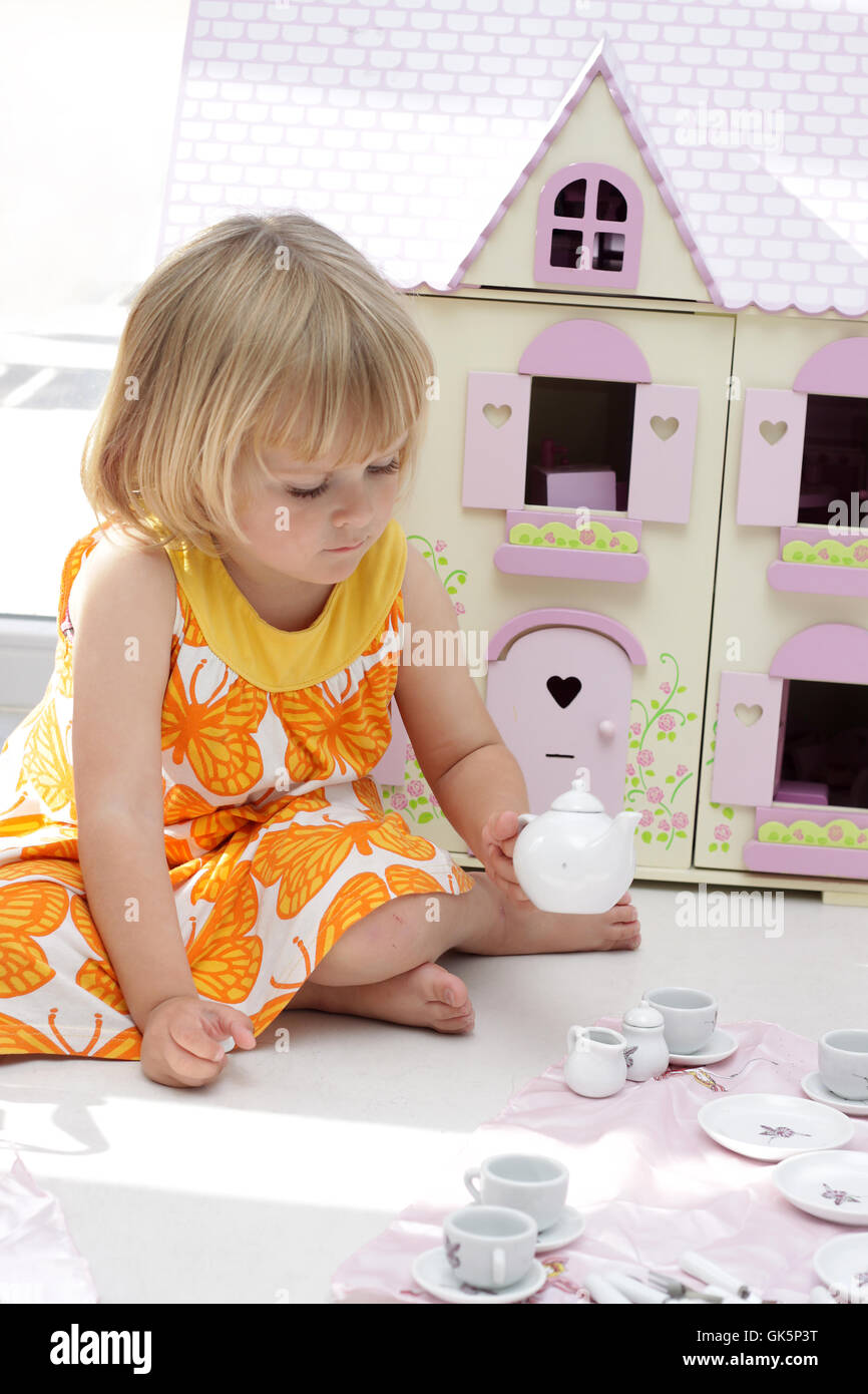 Girl playing tea party with teapot set Stock Photo - Alamy