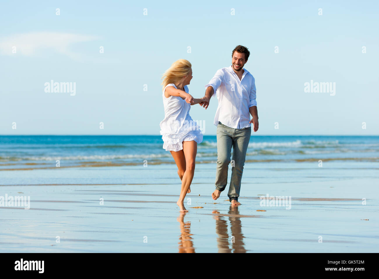 couple on the beach running into great future Stock Photo - Alamy