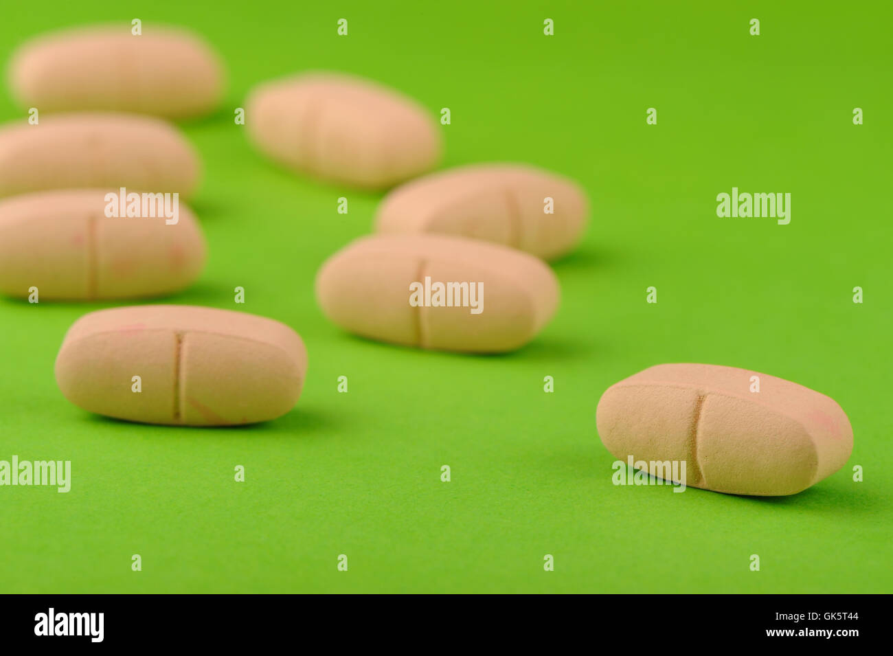 set red tablets on green background Stock Photo - Alamy
