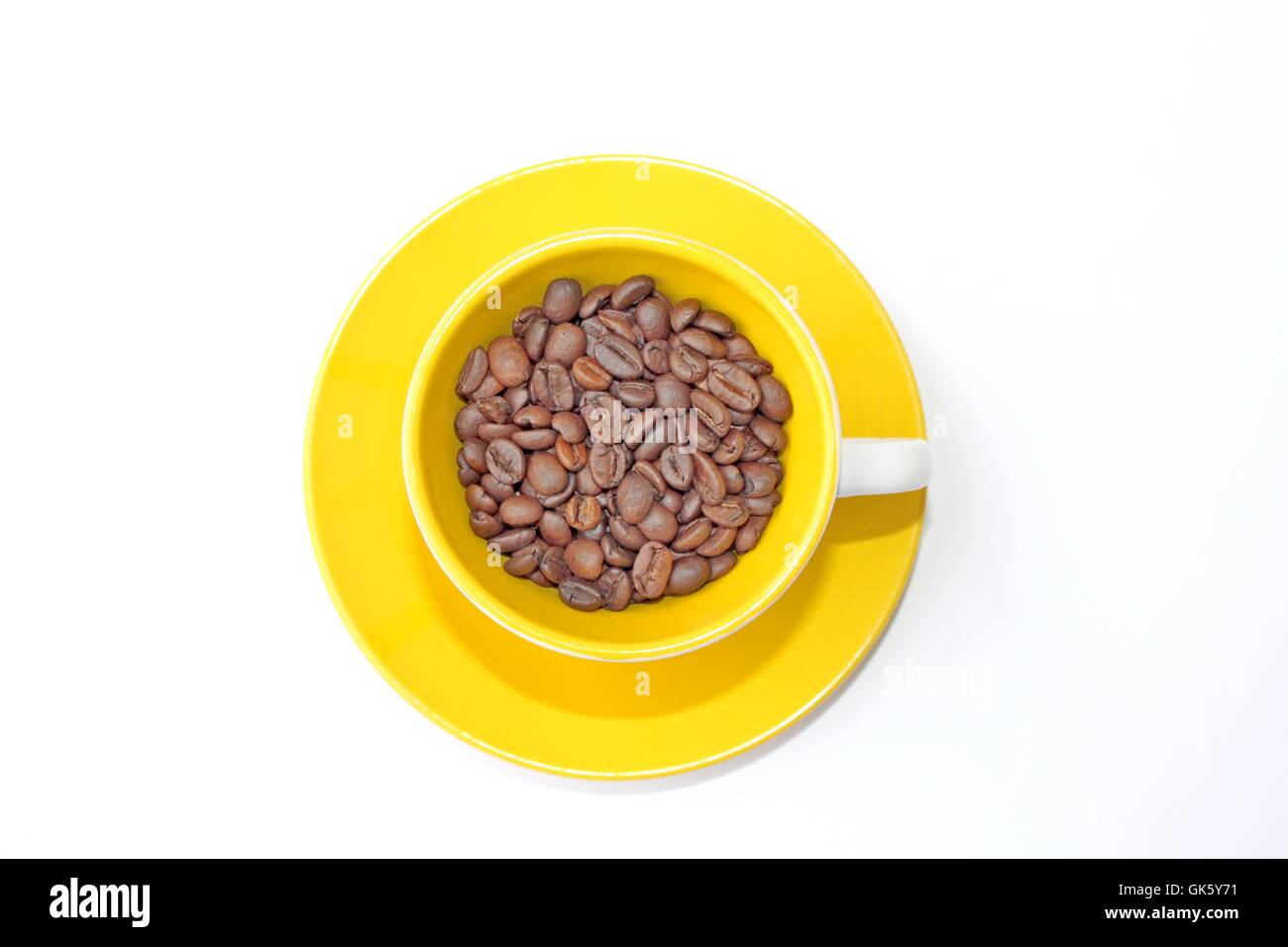 Yellow cup full of coffee beans Stock Photo - Alamy