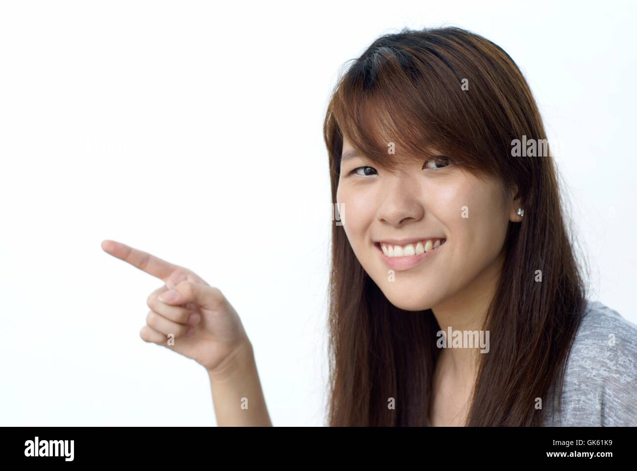 Happy asian teen lady pointing left Stock Photo - Alamy