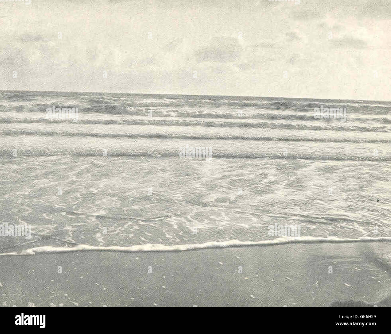 The image shows the fringe of foam left by a bore tide upon a flat ...