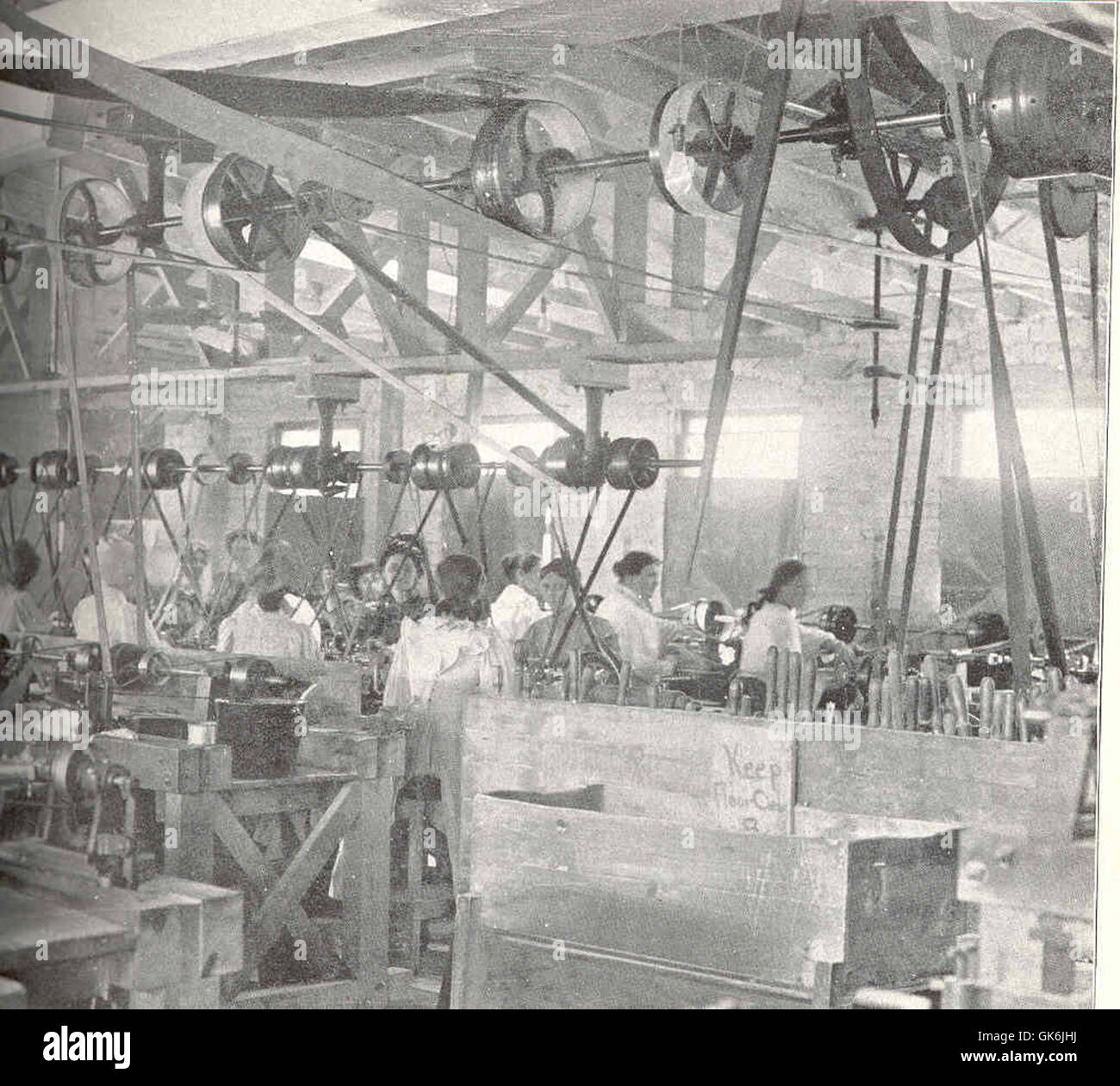 This image shows workers drilling holes into buttons inside a button ...