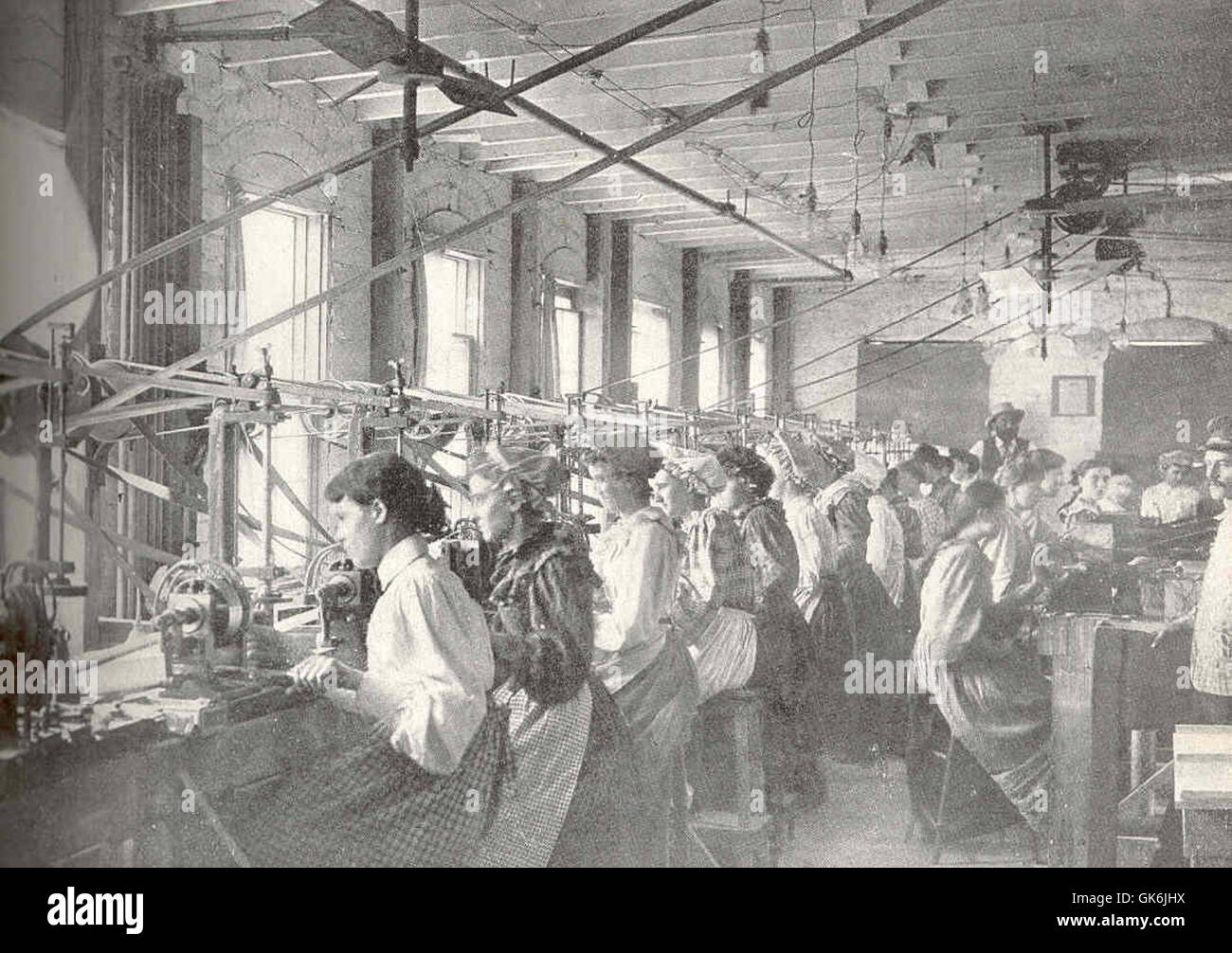 The interior of a button factory shows workers grinding blanks, the ...
