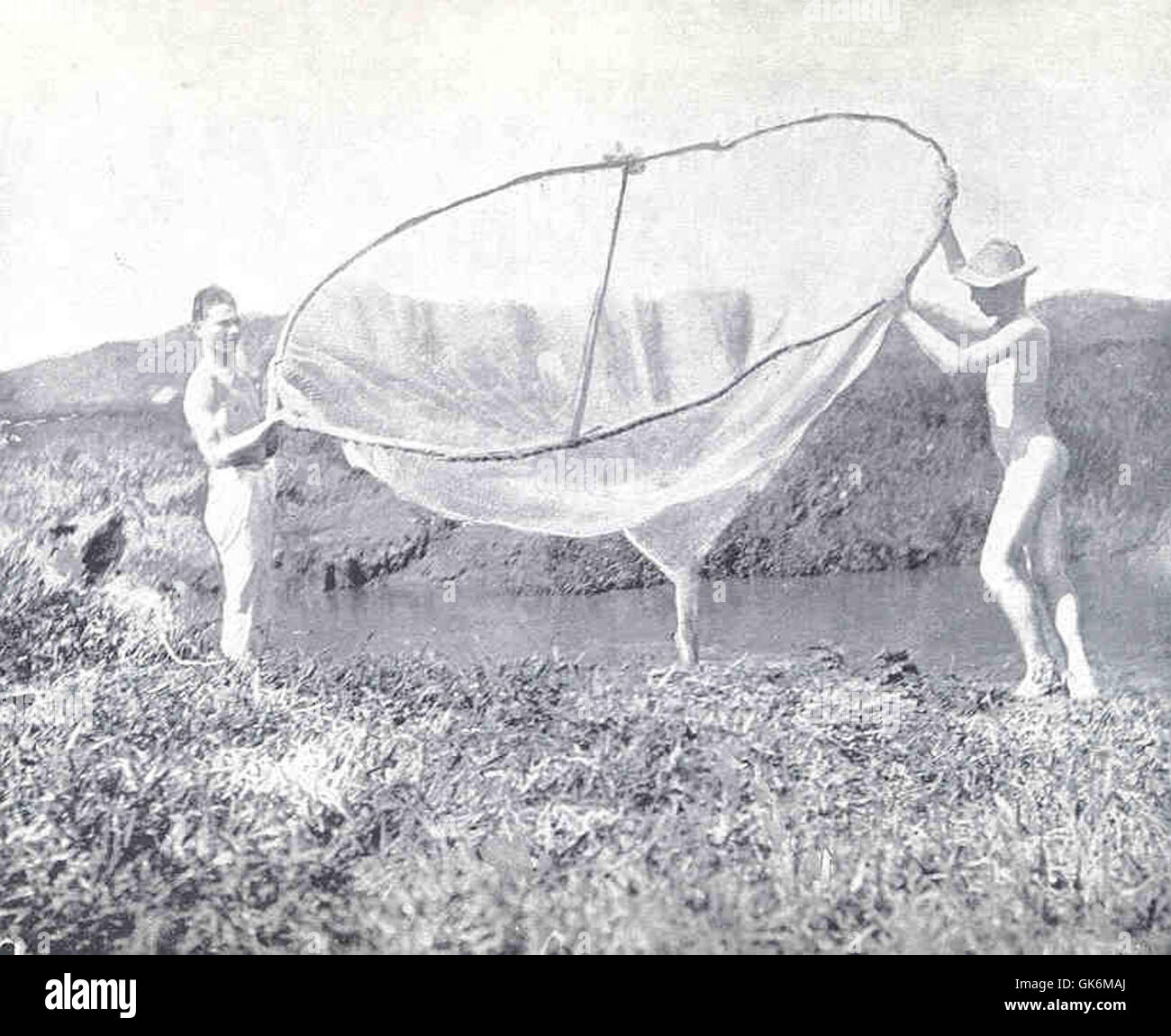 Indigenous people using a traditional hoop net for fishing in the ...