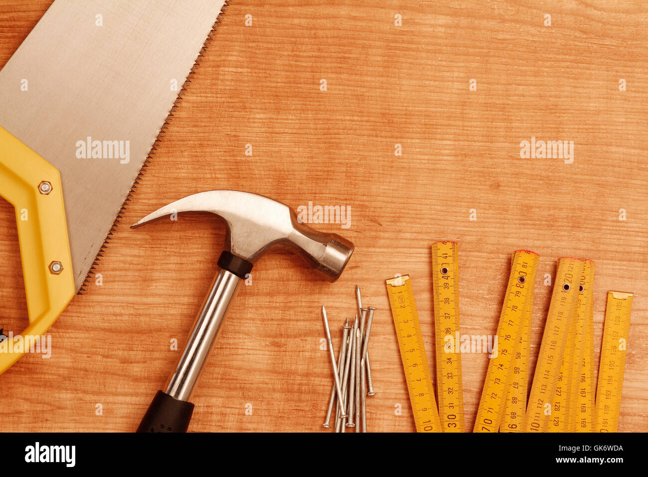 Hammer, nails, ruler and saw on wood. Copy space Stock Photo - Alamy