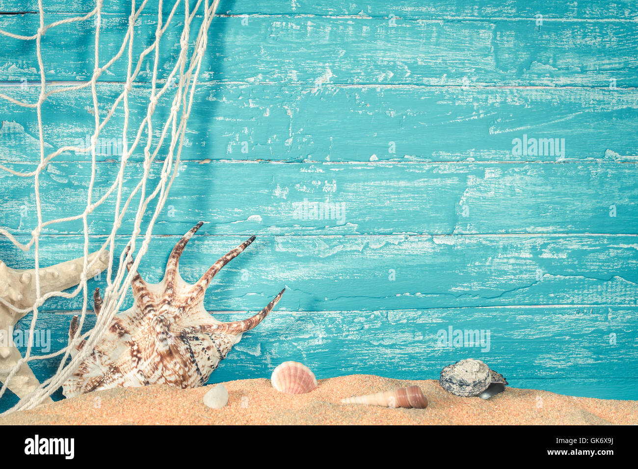 Fishing net and sea shells on sand on blue Stock Photo - Alamy