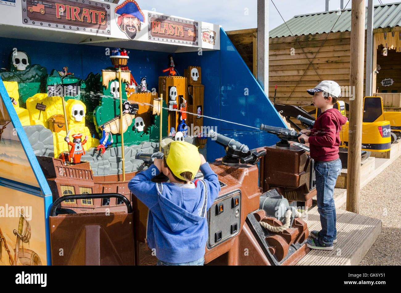 A couple of young brothers play on a water cannon shooting game at the ...