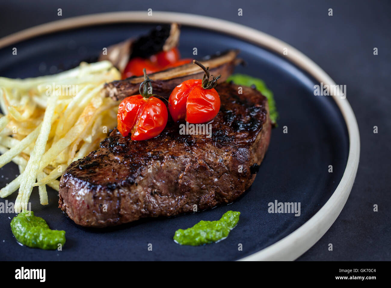 Fillet steak with string fries, roast tomatoes and portobello mushrooms ...